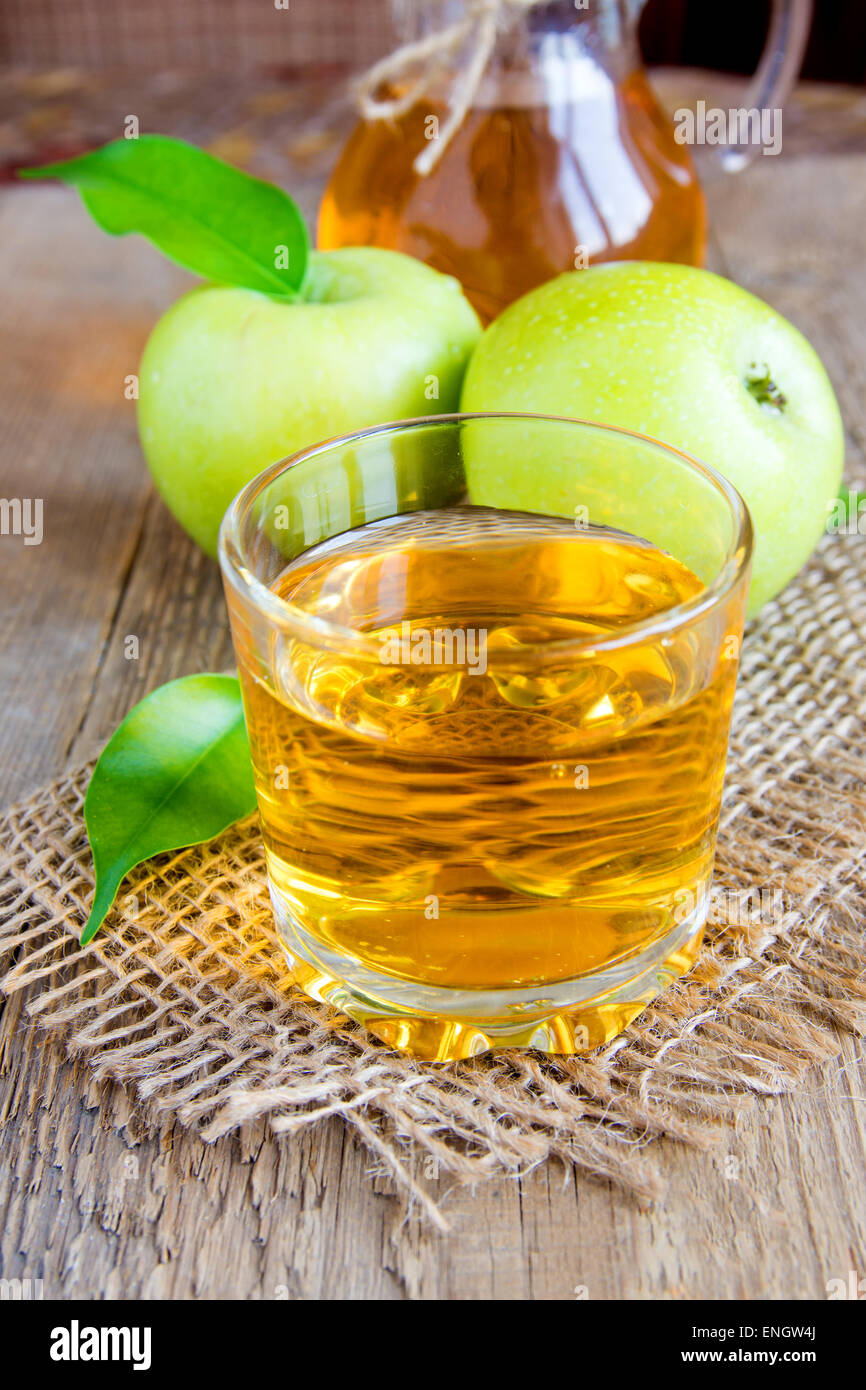 Apple juice (cider) in glass and jug with green apples and leaves on ...