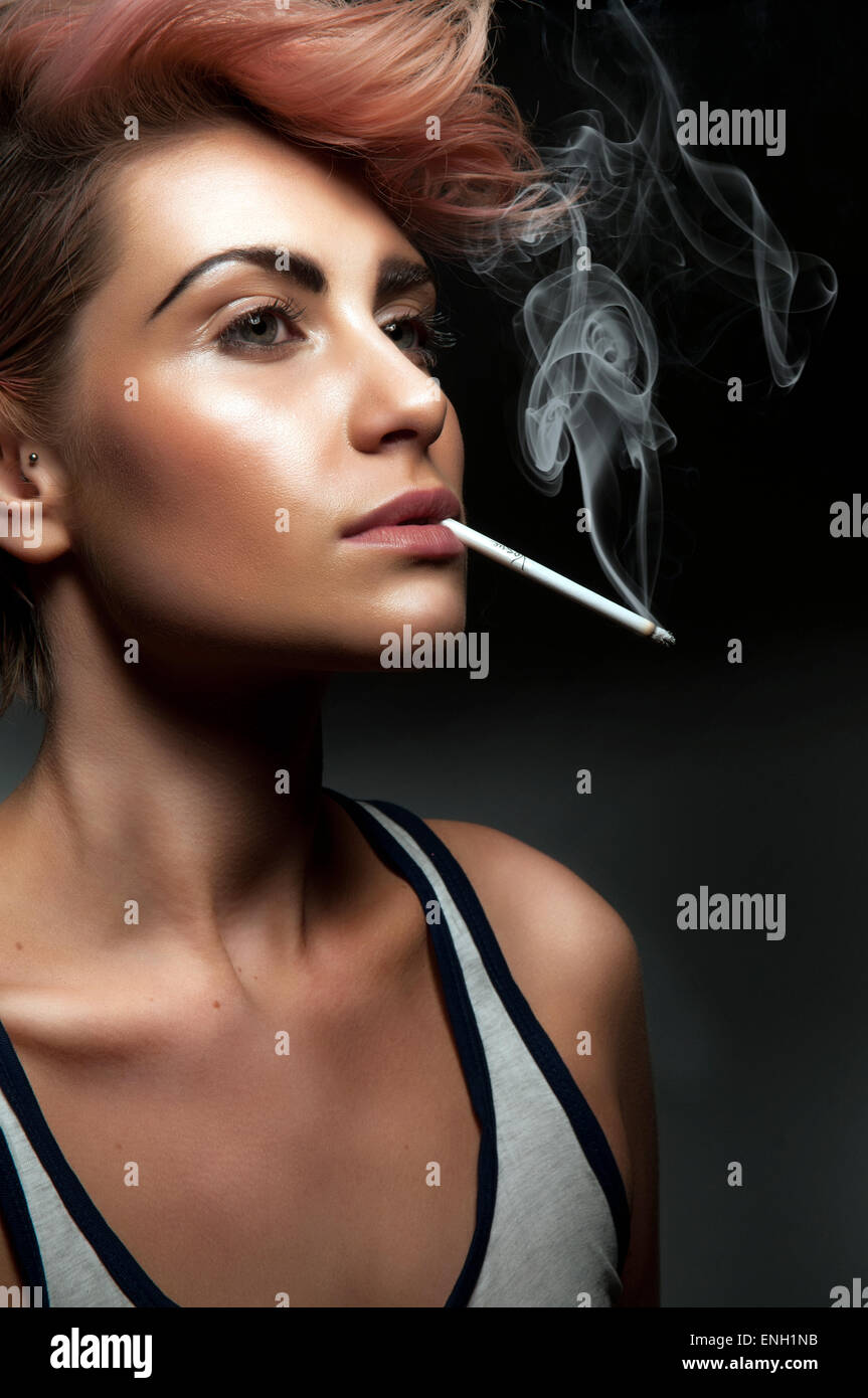 Portrait of young woman with pink hair smoking a cigarette Stock Photo ...