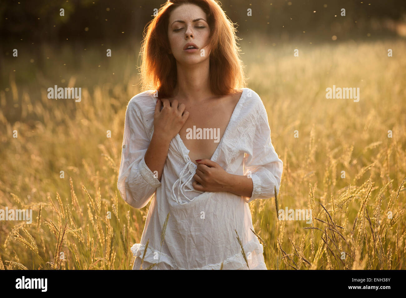 Young Caucasian woman in a white shirt in a field at dusk Stock Photo - Alamy