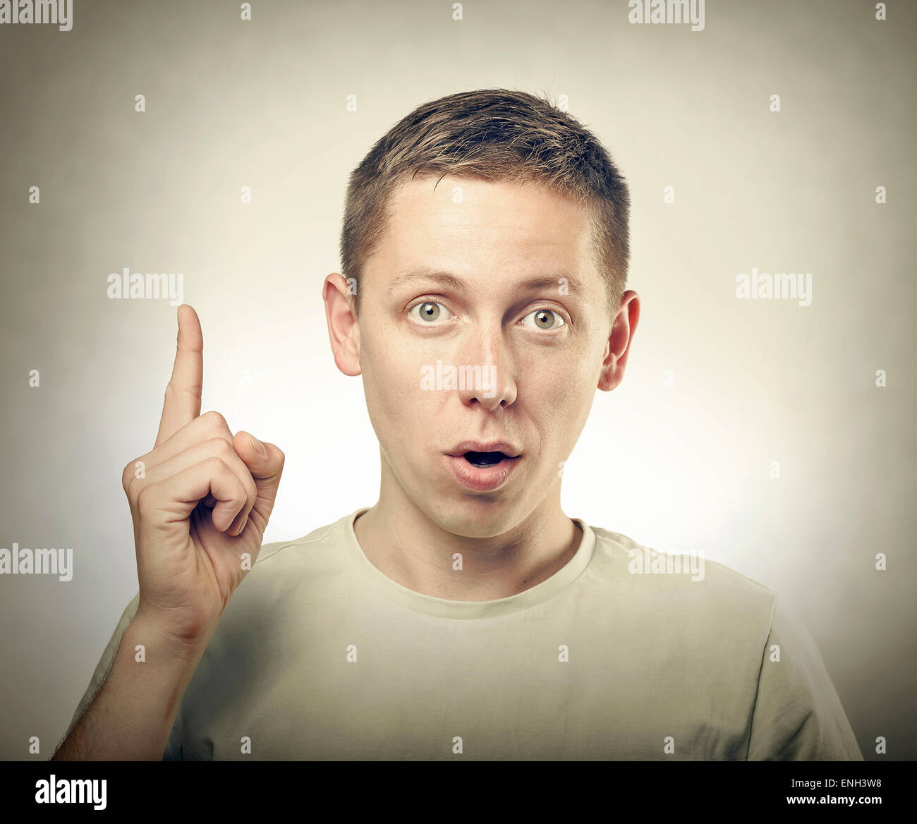 Young man showing upwards index finger Stock Photo - Alamy