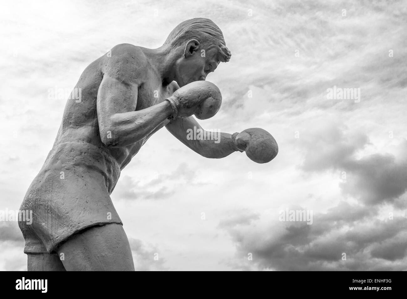 Male statue boxer throwing gloved punches at clouds in monochrome Stock ...