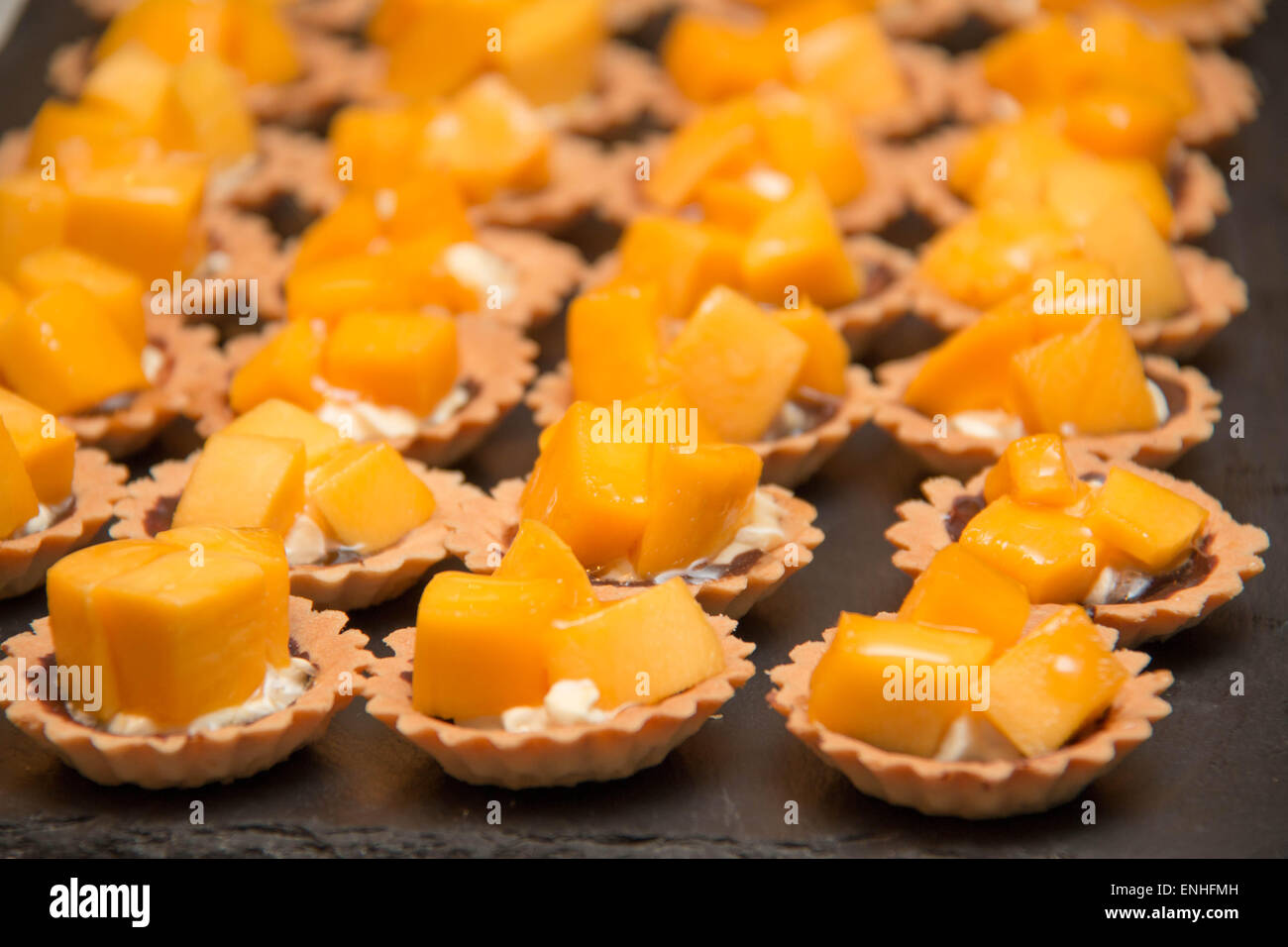 A Fresh baked mango tart on white cup Stock Photo - Alamy