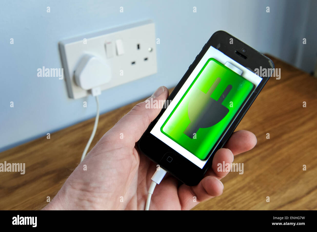 iphone 5 mobile phone on charge in a UK plug socket Stock Photo - Alamy
