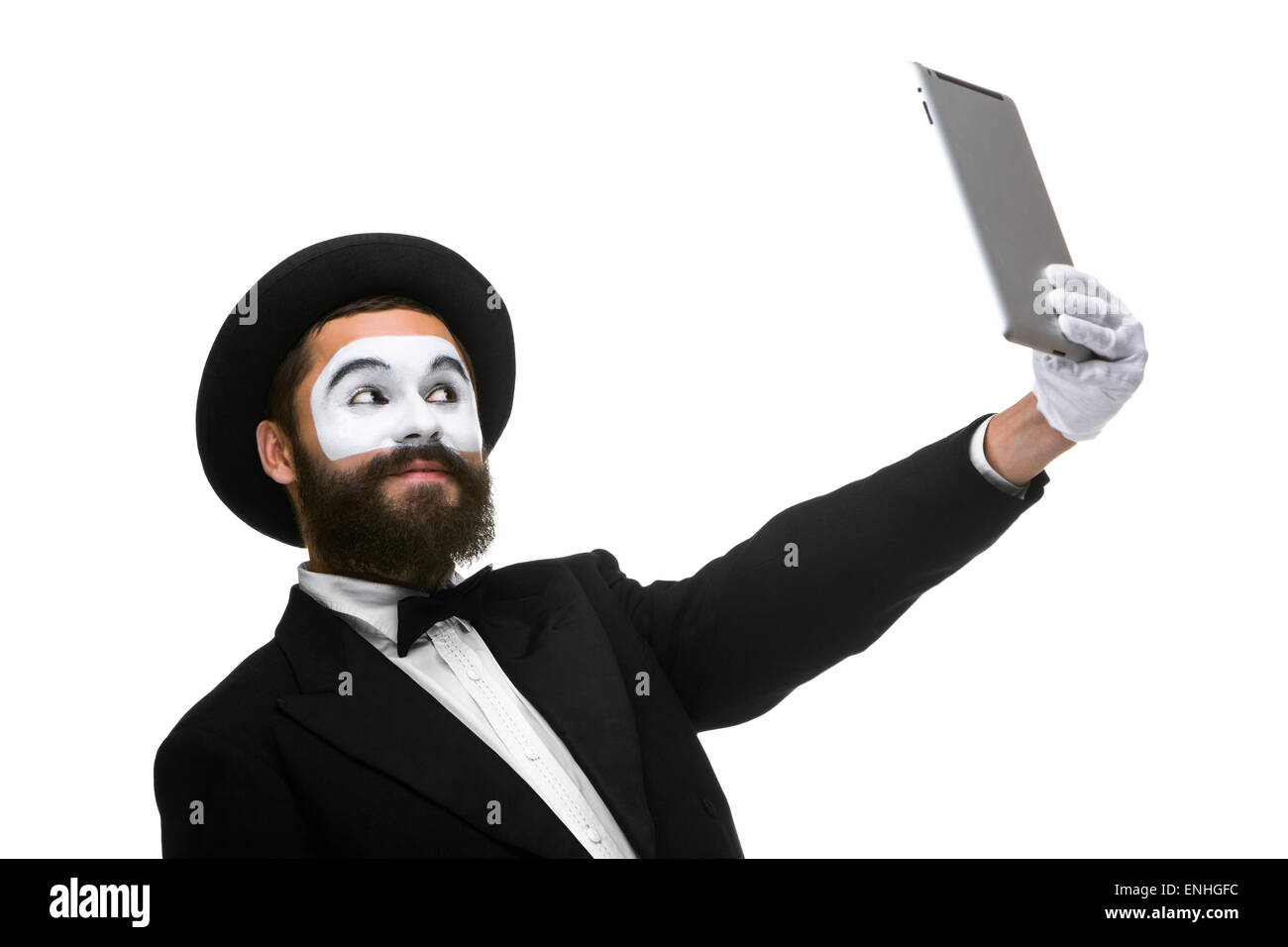 Man with a face mime working on a laptop isolated on a white background ...