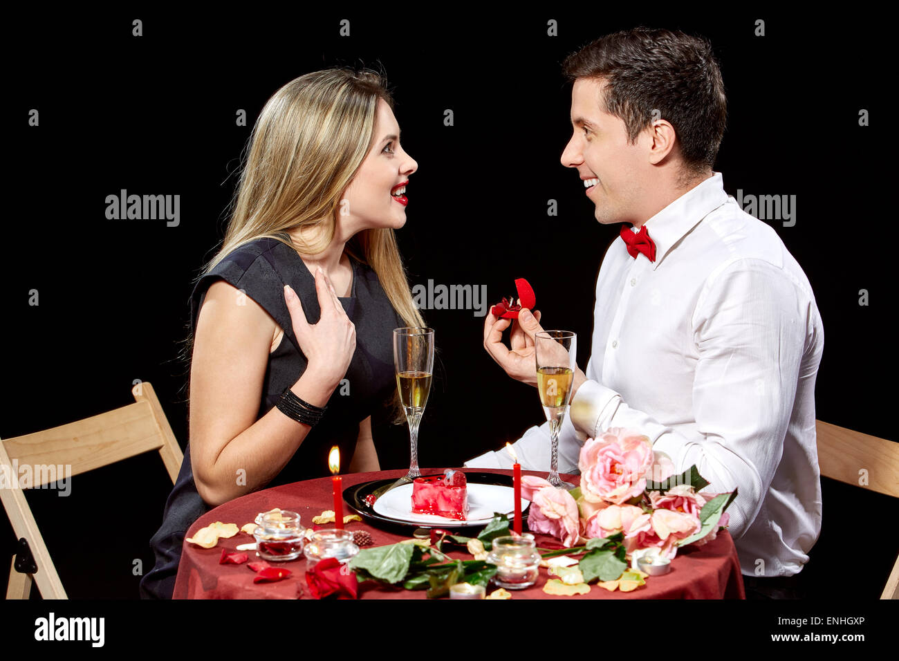 Man proposing marriage to a surprised woman on black background Stock ...