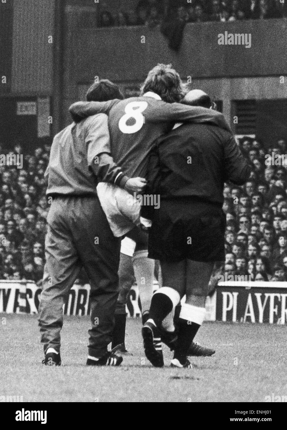 Everton footballer Mike Bernard carried off the pitch aided by a ...