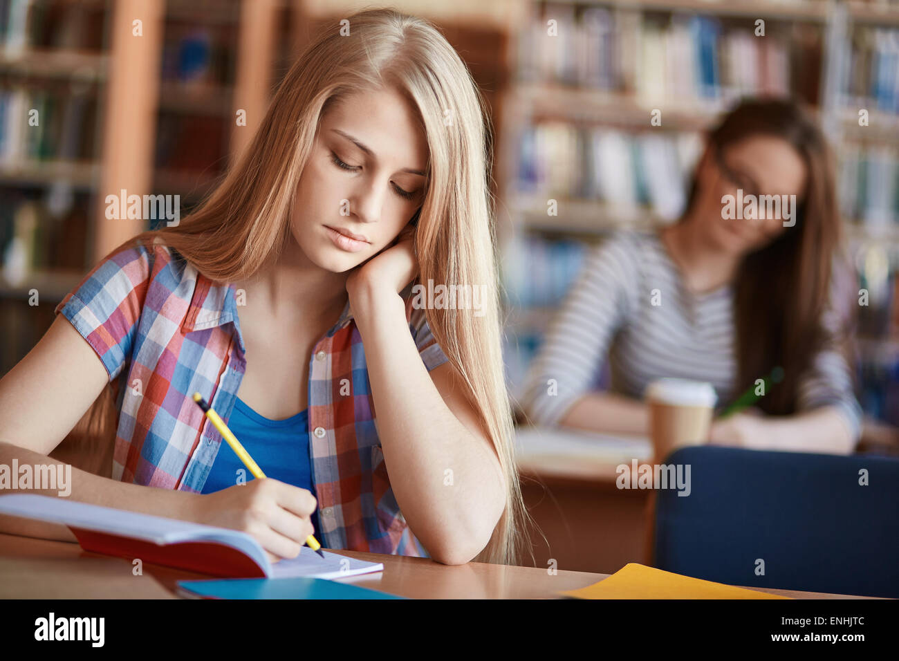 Serious girl making notes at lesson in college Stock Photo - Alamy