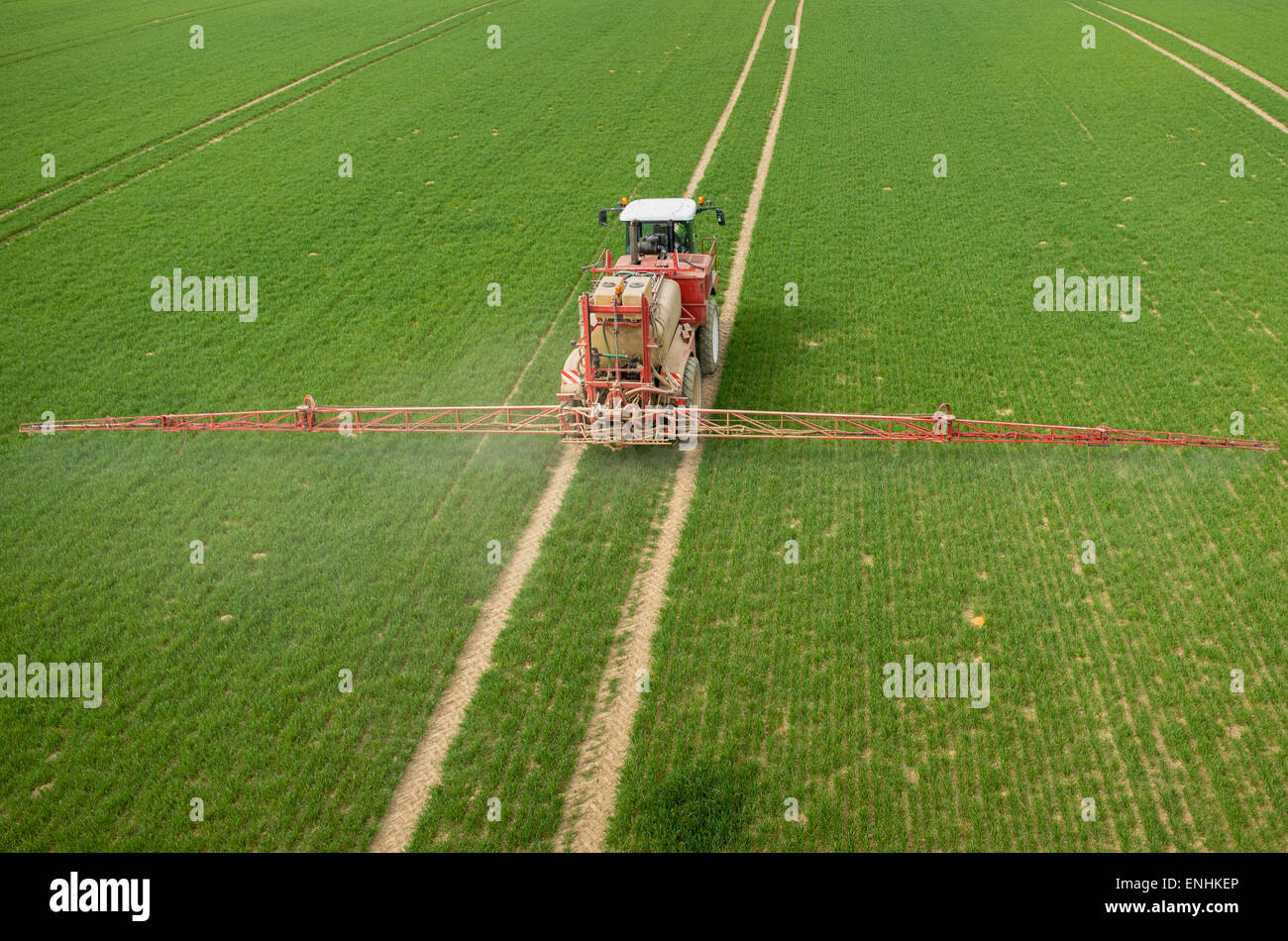 Aerial view of the tractor spraying the chemicals on the large green ...