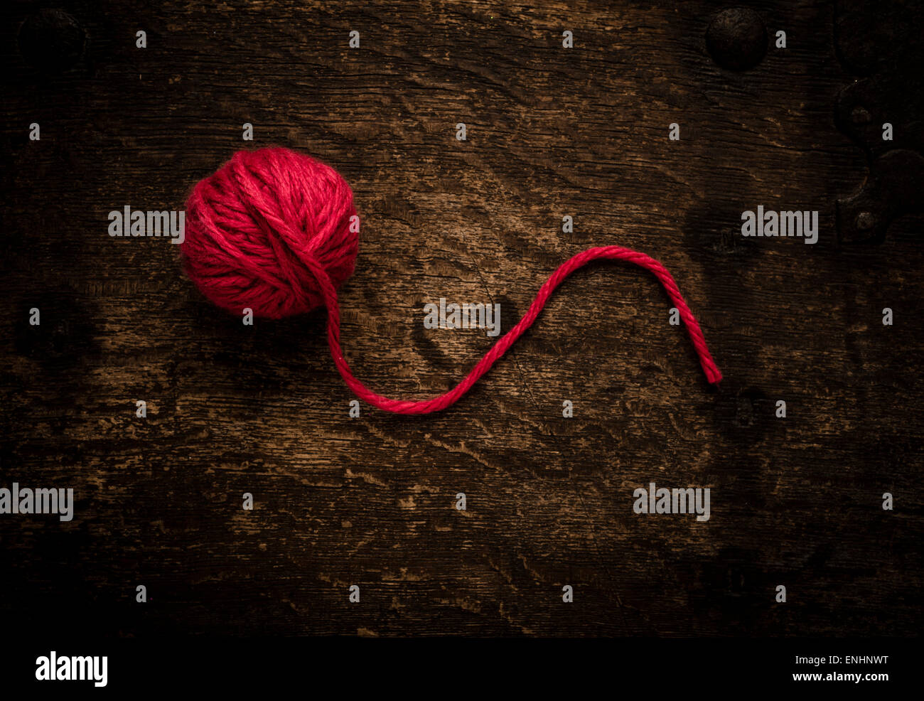Still life of ball of red yarn on wooden table. Conceptual image of ...