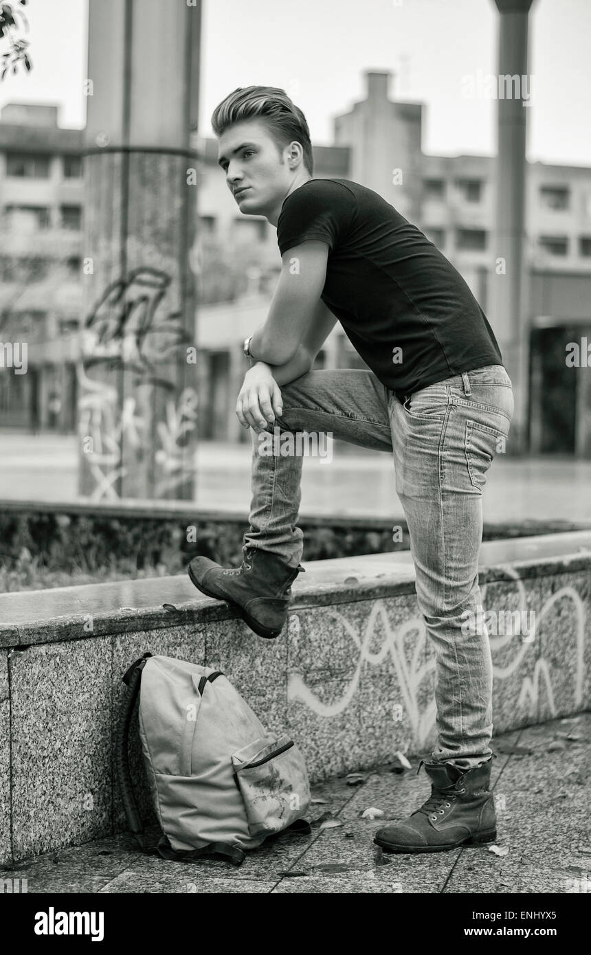 Attractive young man with backpack standing outside Stock Photo - Alamy