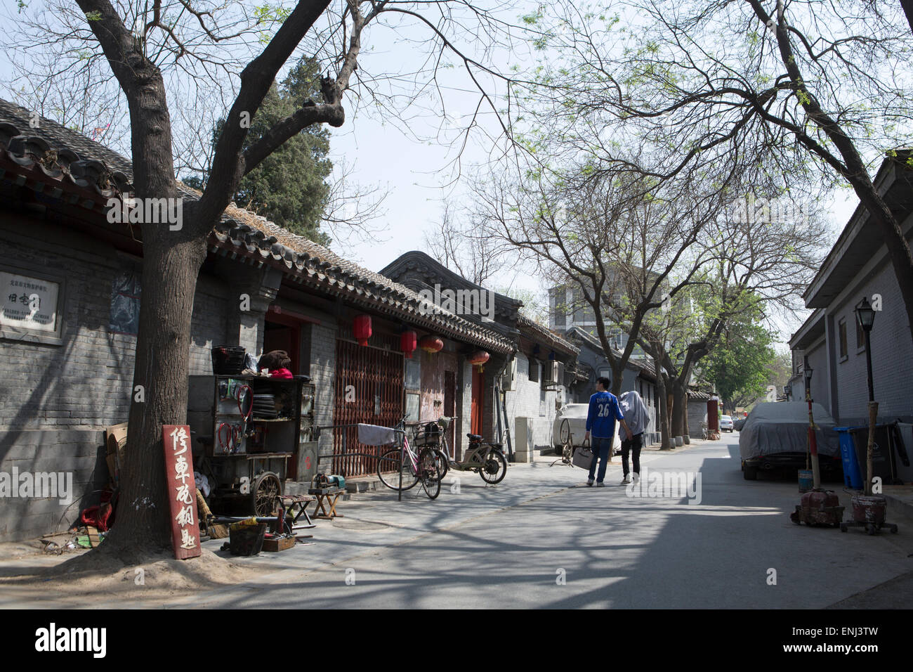 A traditional hutong (narrow street or alleyway) bordered by courtyard ...