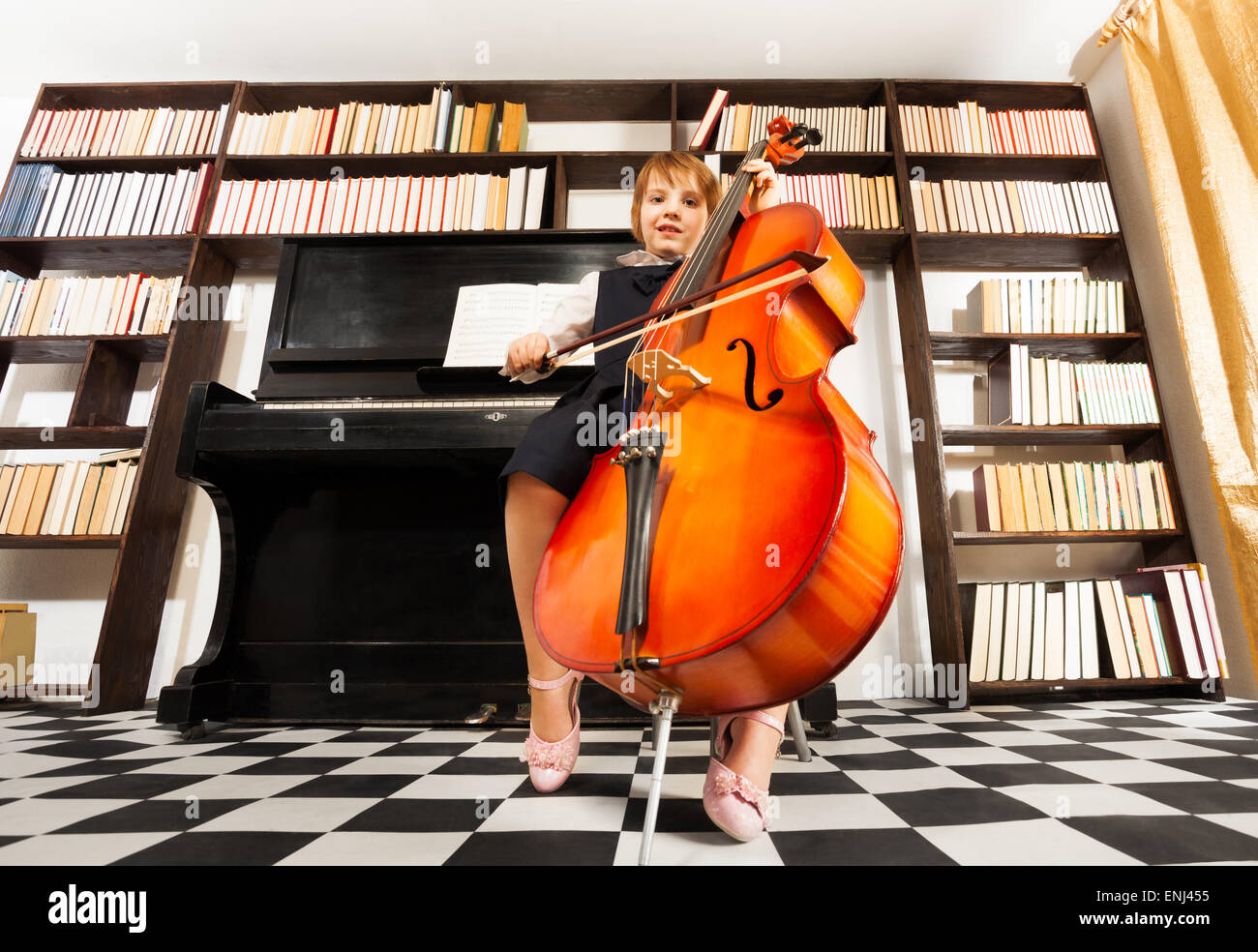 One small girl in uniform dress playing on cello Stock Photo - Alamy
