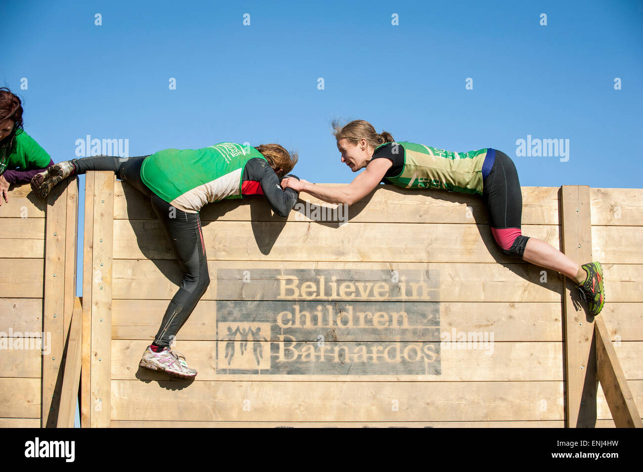 Women climbing the 10 foot wall and helping each other, Dirty Dozen ...