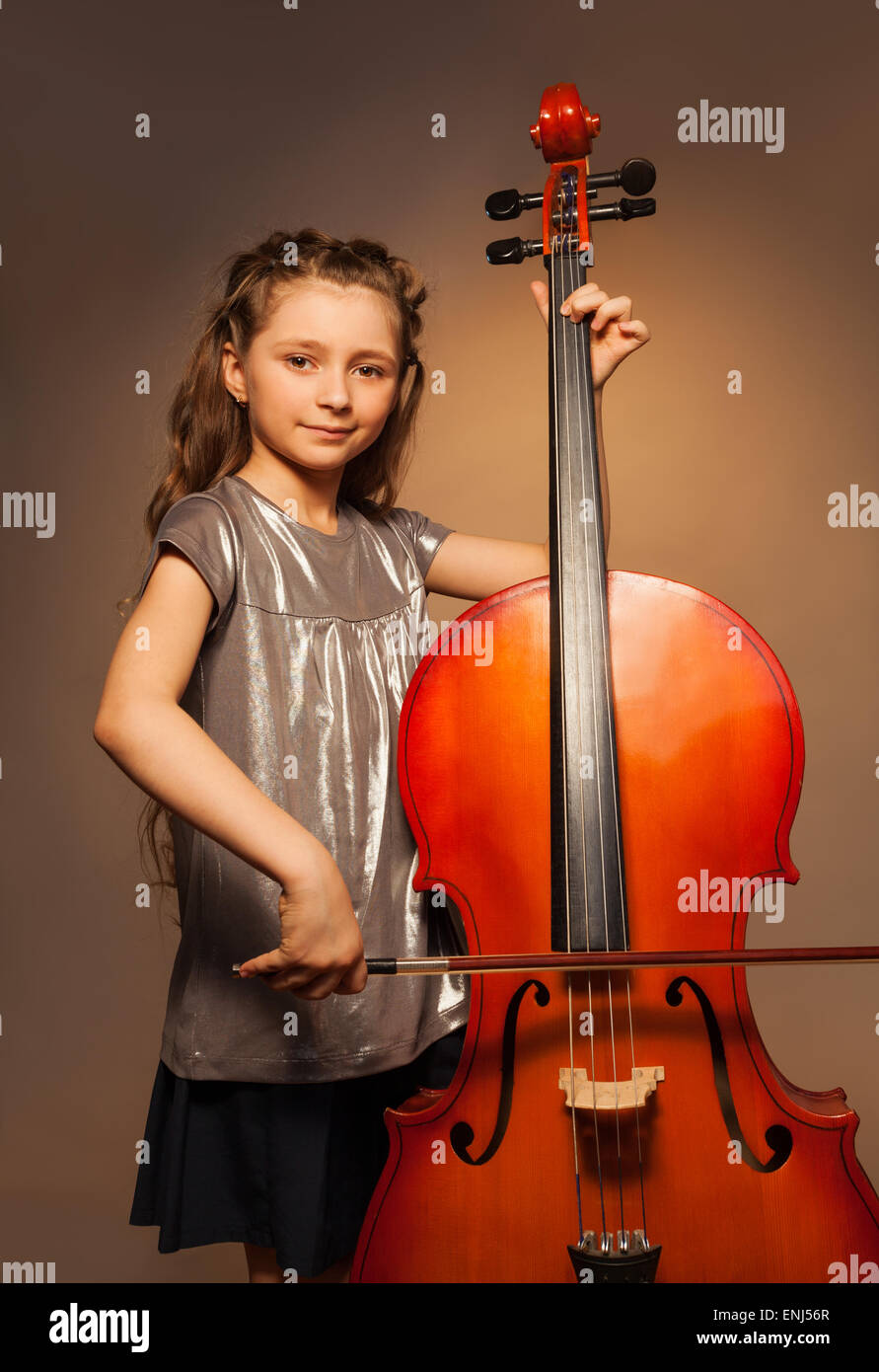 Classy girl with long hair holding cello to play Stock Photo - Alamy