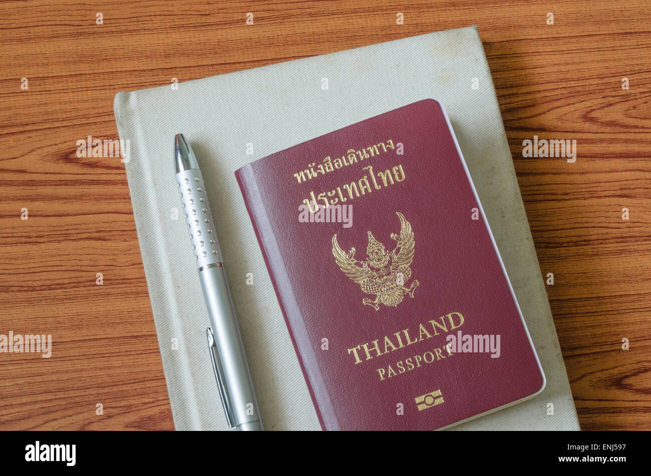 thai passport with notebook on wood table background Stock Photo - Alamy