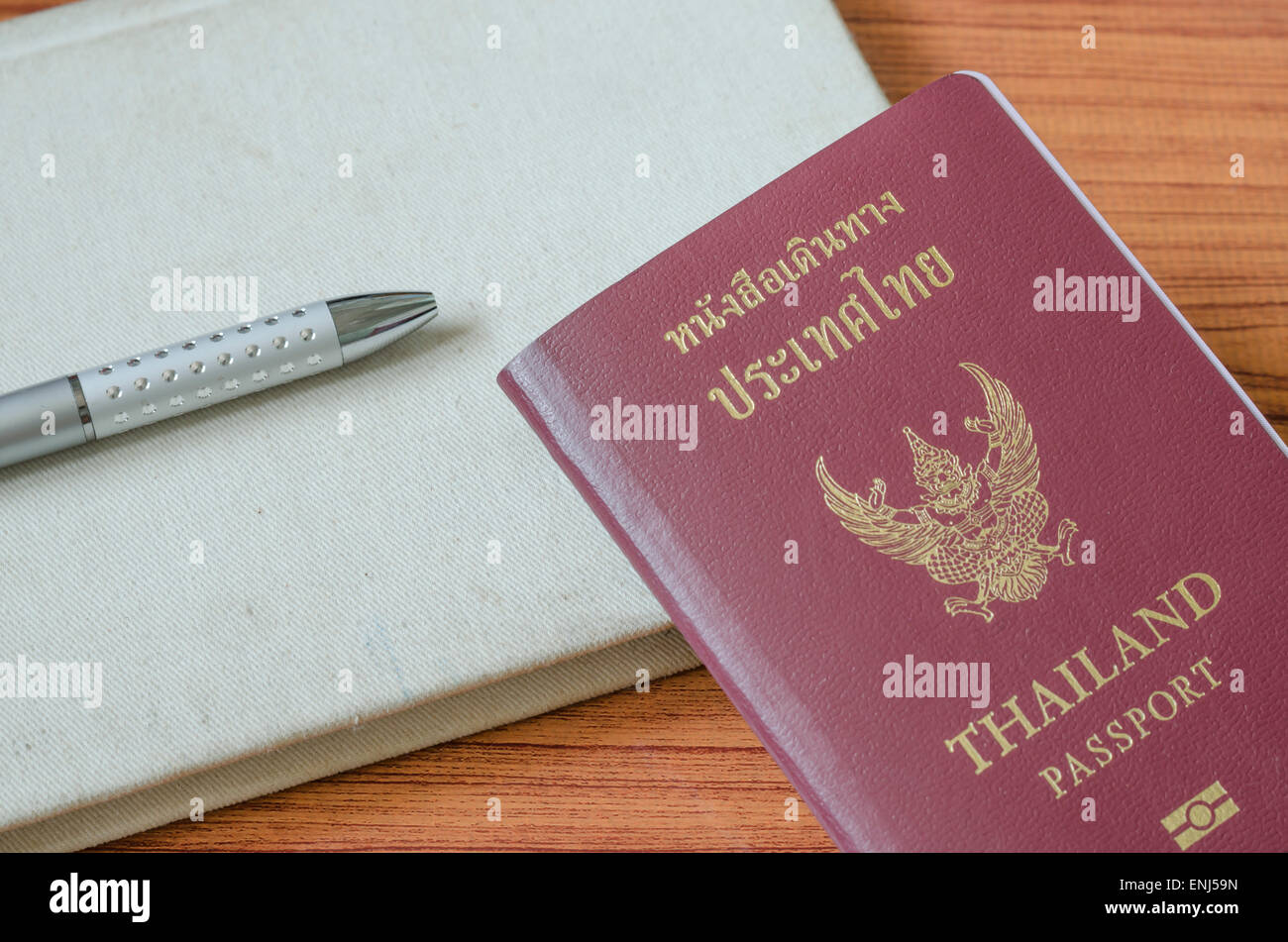 thai passport with notebook on wood table background Stock Photo - Alamy