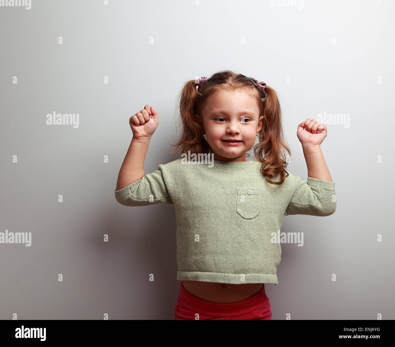 Strong happy successful girl showing muscular on blue wall background ...