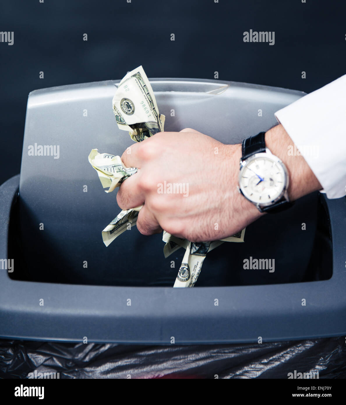 Concept image of a businessman hands throwing US dollar bills in trash ...