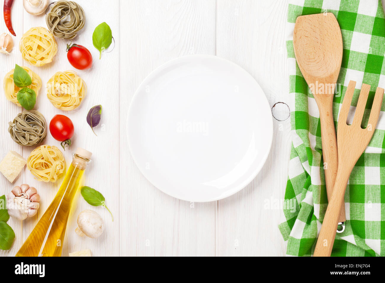 Italian food cooking ingredients and empty plate. Pasta, tomatoes ...