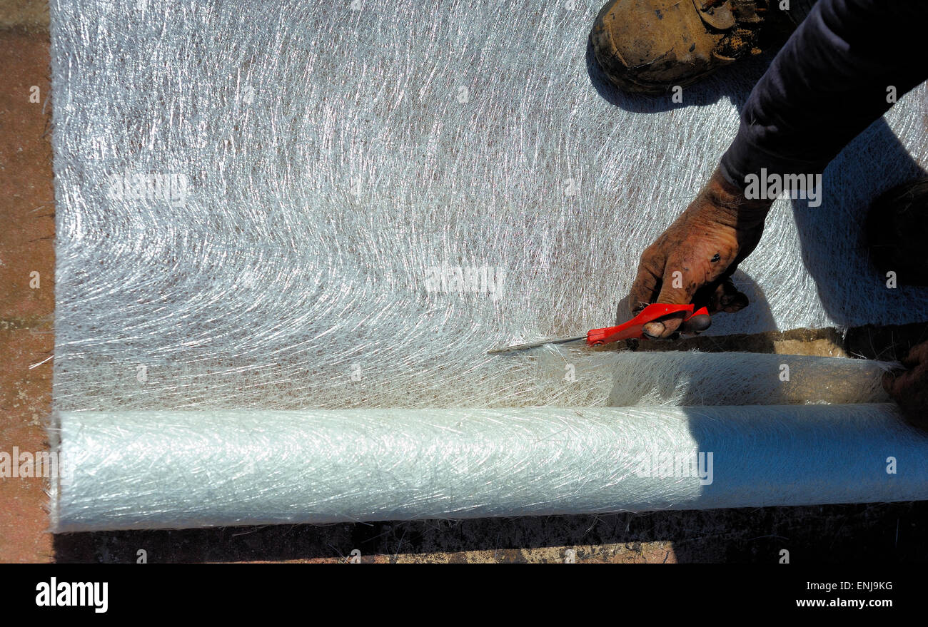 Worker cuts to size with a scissor, sheet of fiberglass Stock Photo - Alamy