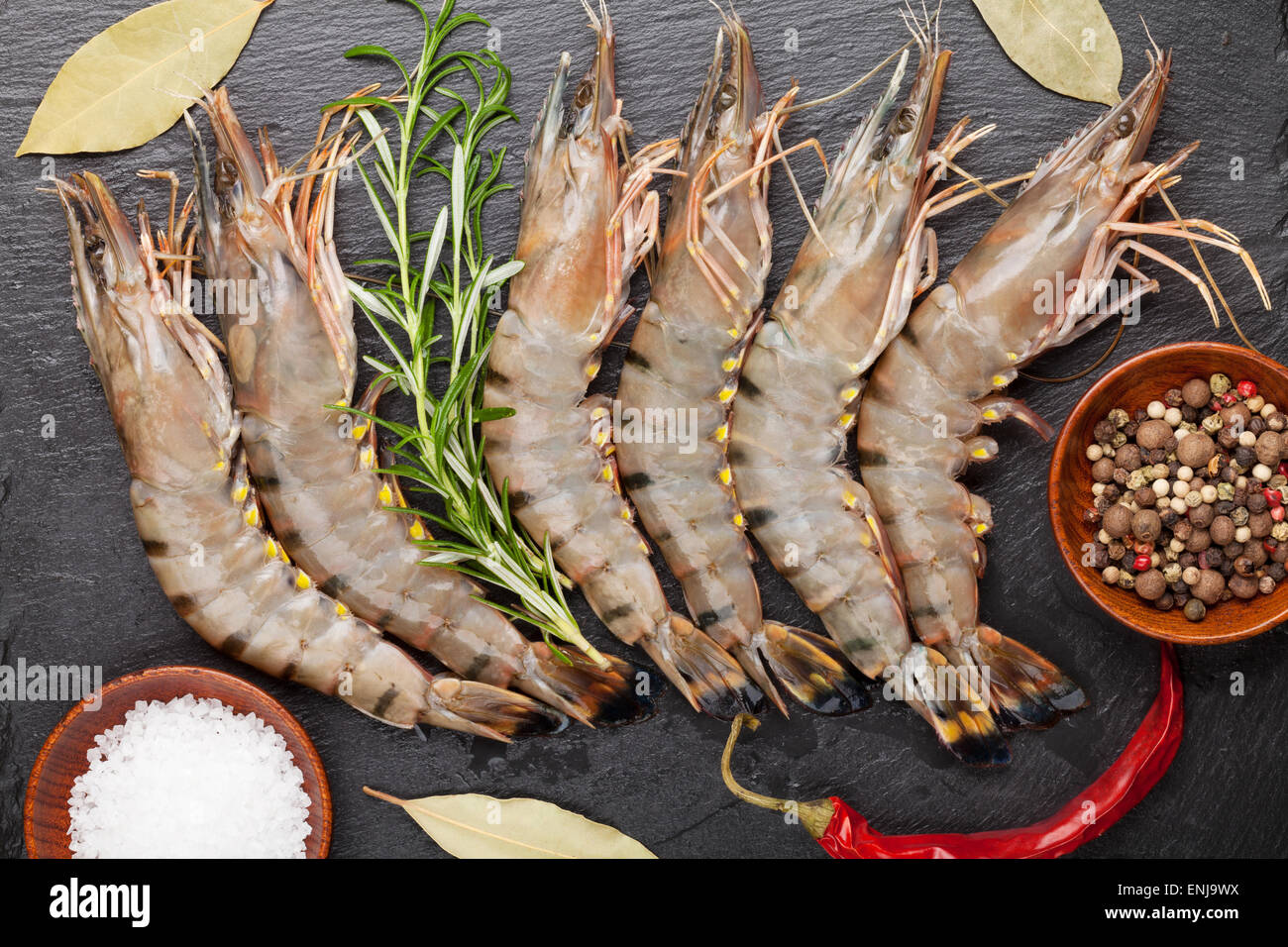 Fresh raw tiger prawns and spices on black stone plate. Top view Stock ...