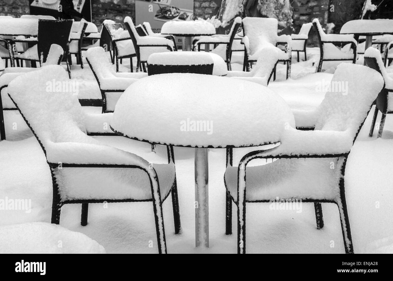 Snow and ice covering cafe chairs and tables in a wintery Gulhane Park ...