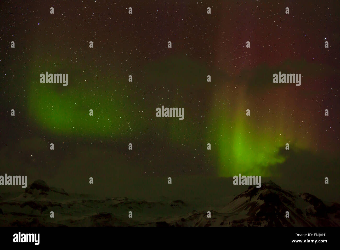 Different colors of northern lights in Iceland with mountains in ...