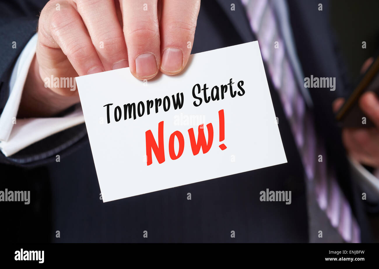 A businessman holding a business card with the words, Tomorrow Starts ...
