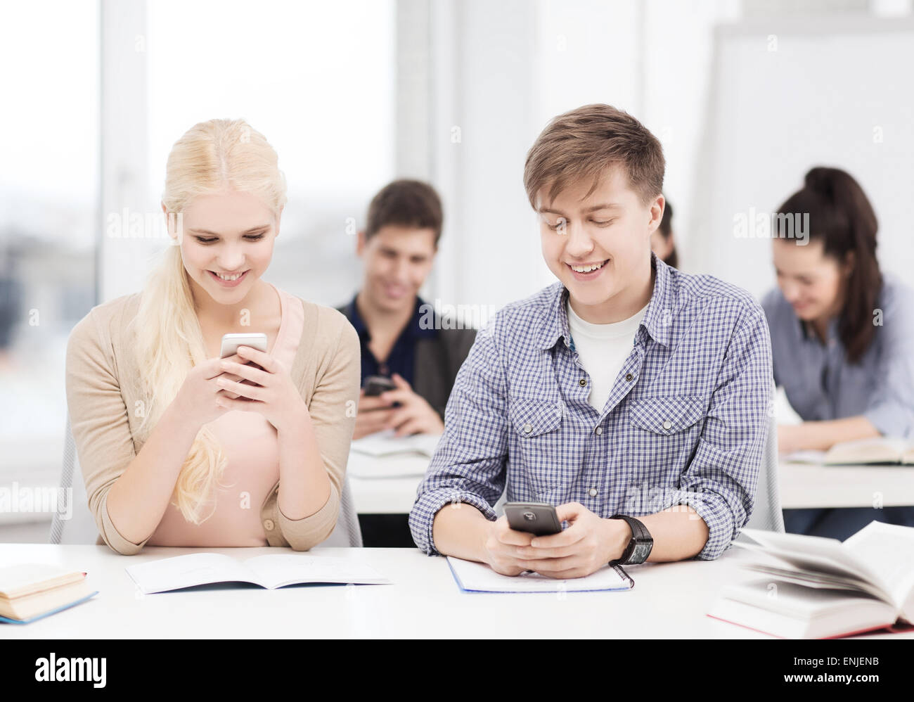 students looking into smartphone at school Stock Photo - Alamy