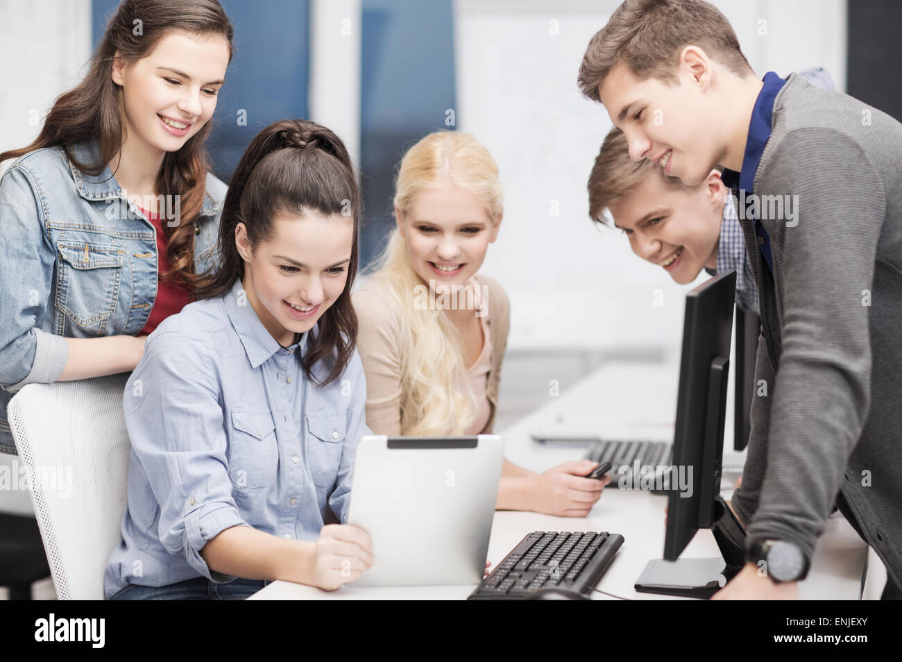 students with computer monitor and tablet pc Stock Photo - Alamy