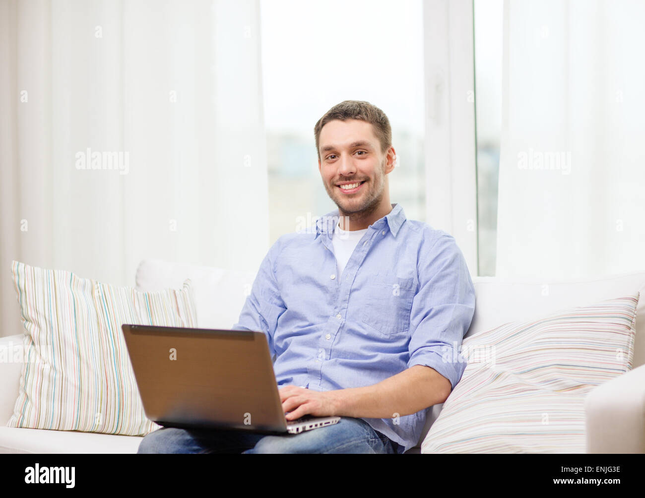 smiling man working with laptop at home Stock Photo - Alamy