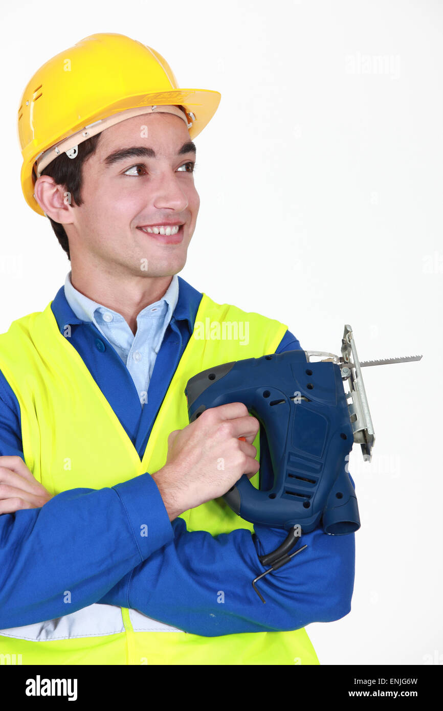 Smiling worker with an electric jigsaw Stock Photo - Alamy