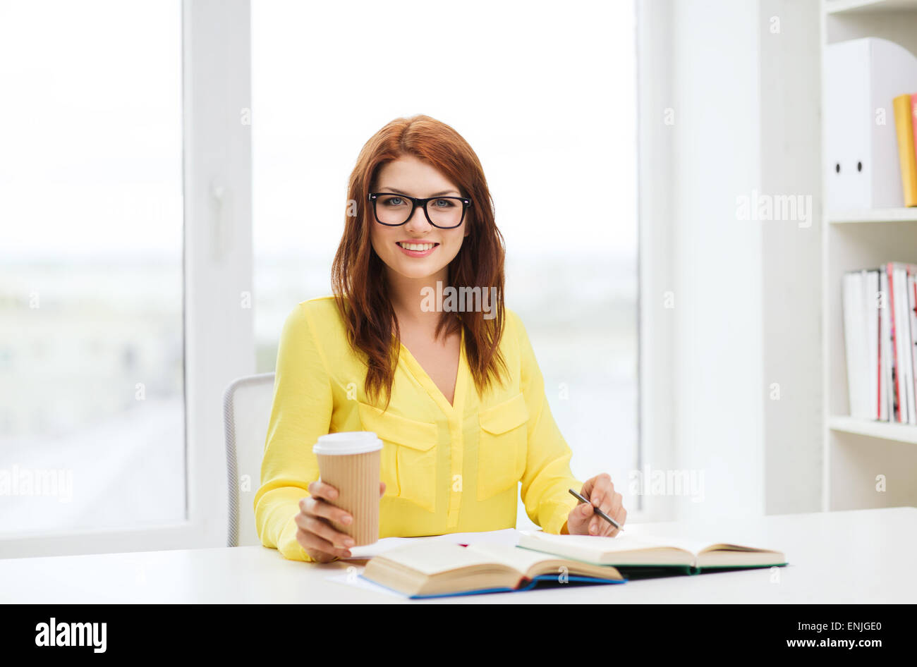 smiling student girl reading books in library Stock Photo - Alamy