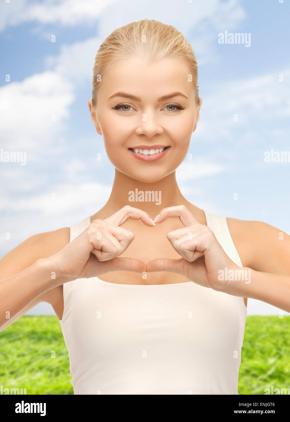 smiling woman showing heart shape gesture Stock Photo - Alamy