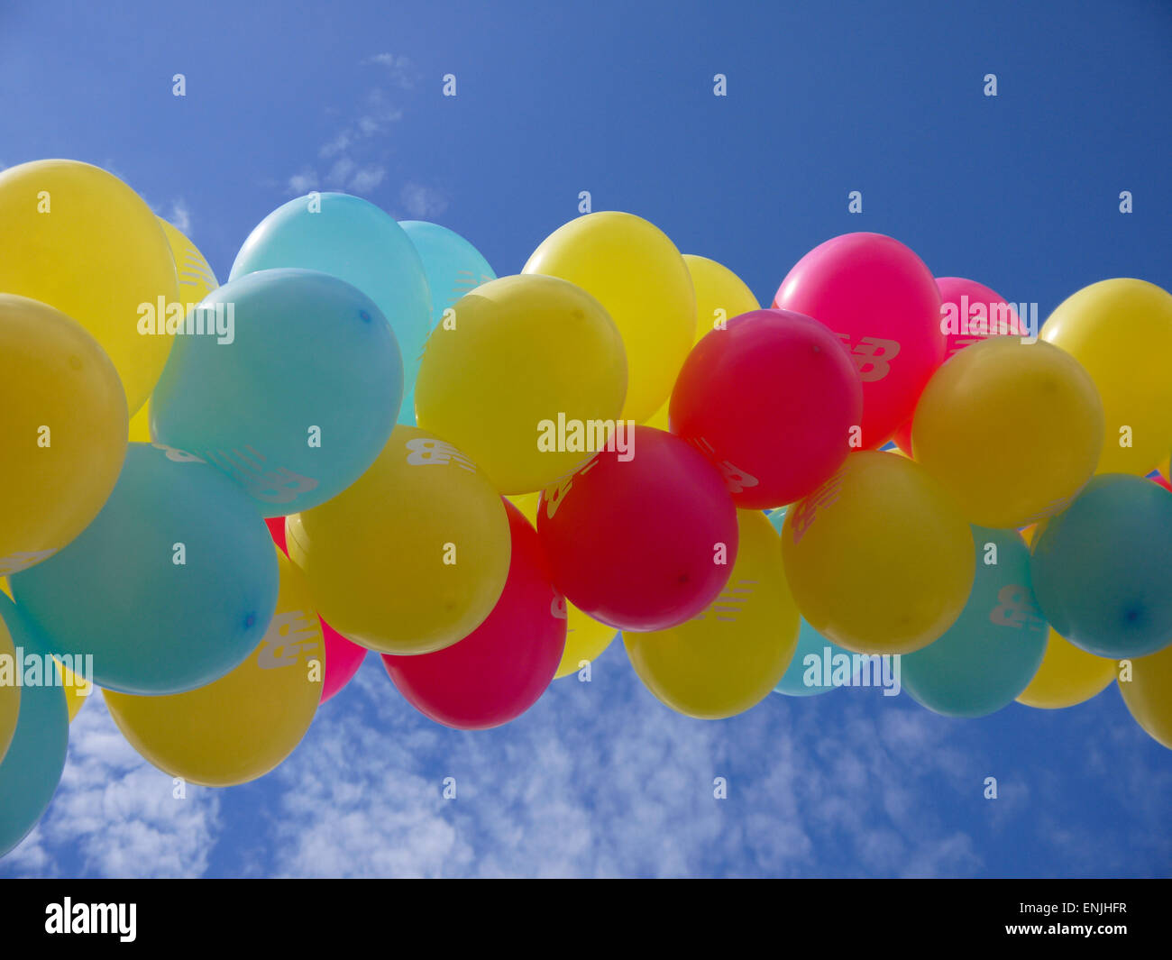 String of coloured balloons against a blue sky with clouds Stock Photo ...