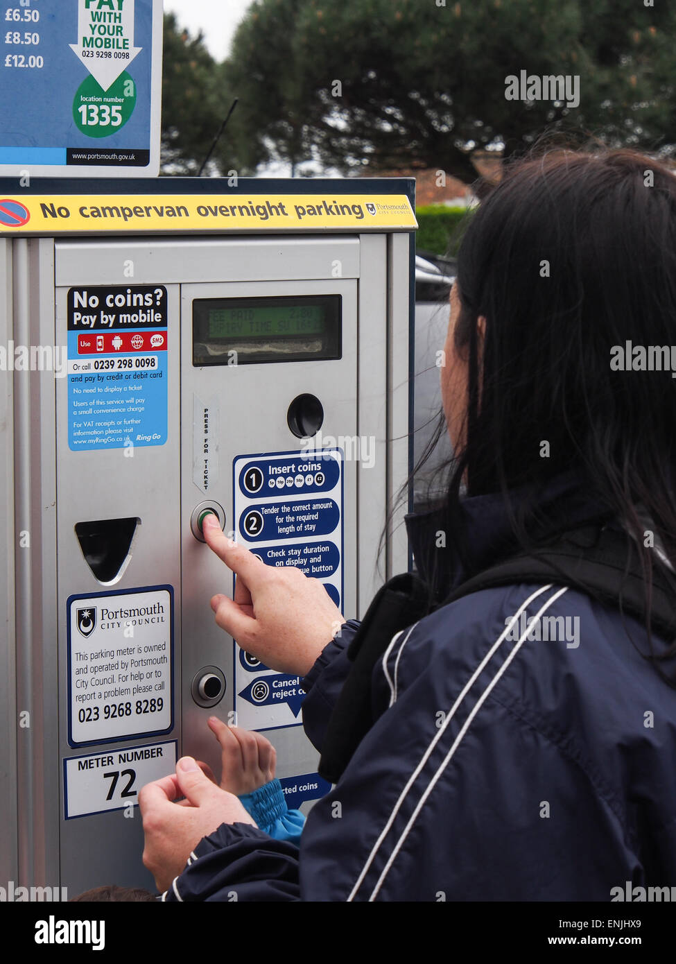 A lady using a pay and display parking machine Stock Photo - Alamy