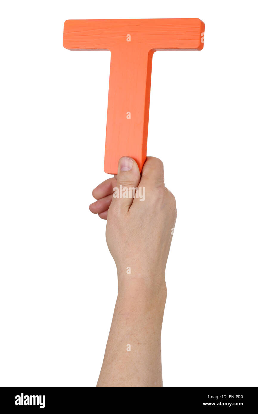 Hand holding letter T from alphabet isolated on a white background ...