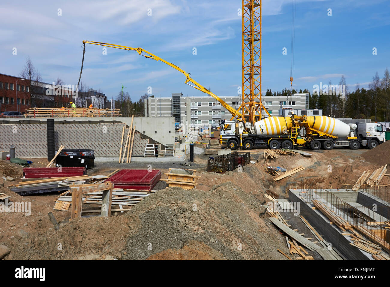 Building under construction with trucks delivering concrete, Finland ...