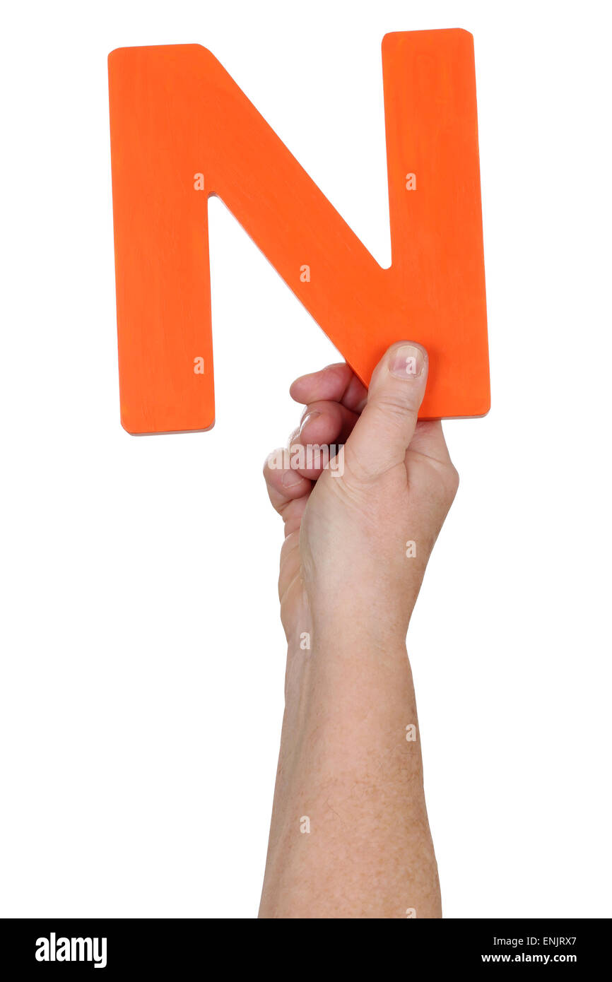 Hand holding letter N from alphabet isolated on a white background ...