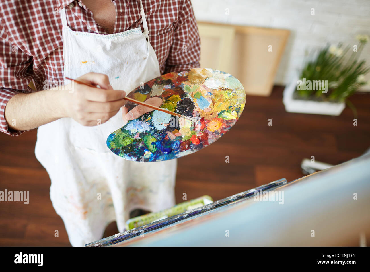 Close-up of artist hands with paintbrush and palette mixing water ...