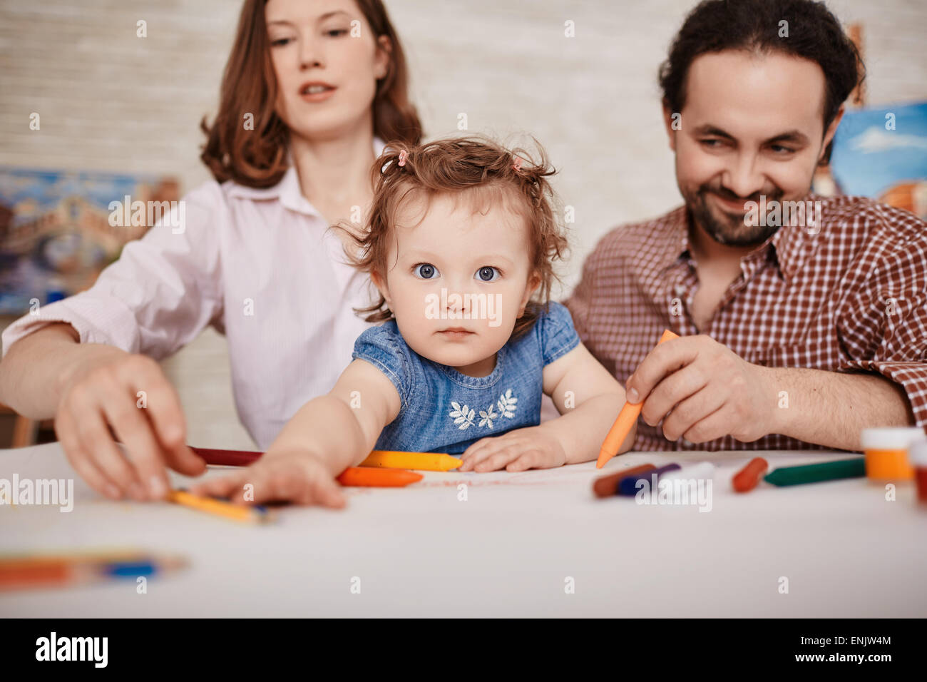 Small girl looking at camera on background of her parents Stock Photo ...