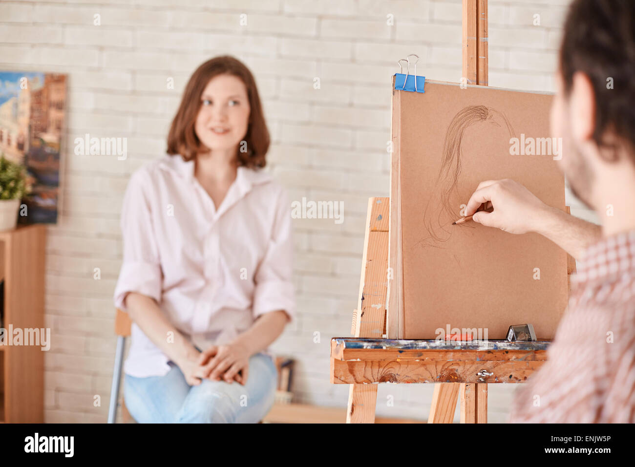 Male artist drawing young woman in studio Stock Photo - Alamy