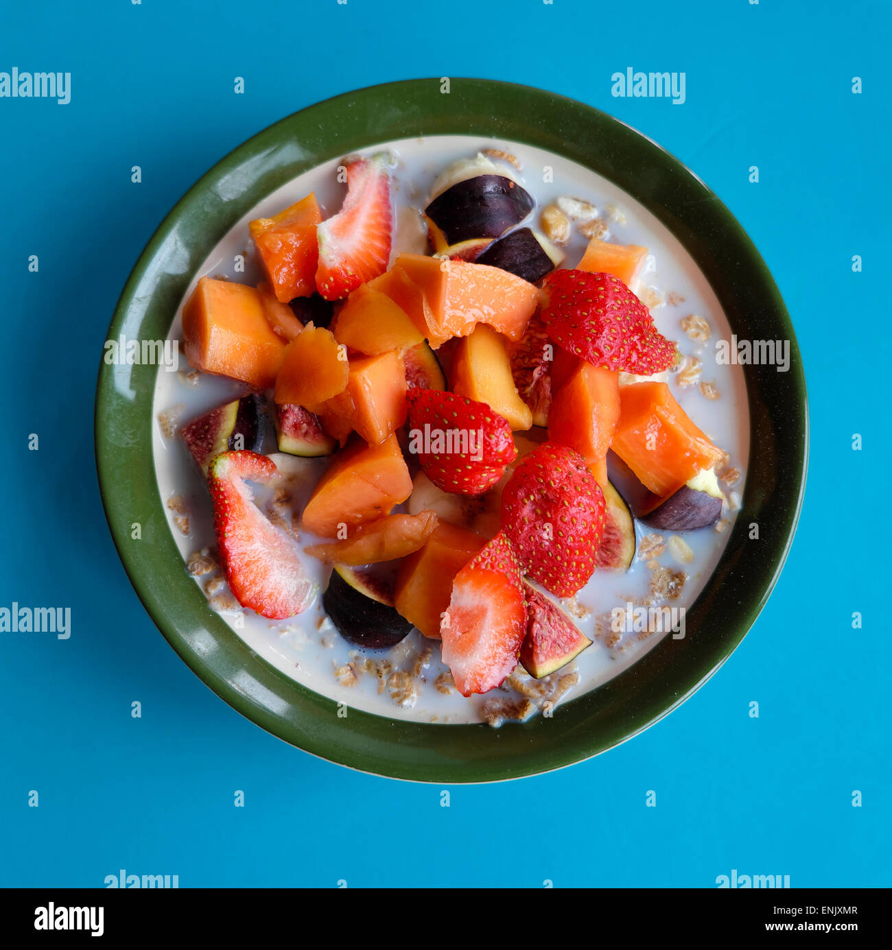 A bowl of muesli breakfast cereal with fresh fruit viewed from above on ...