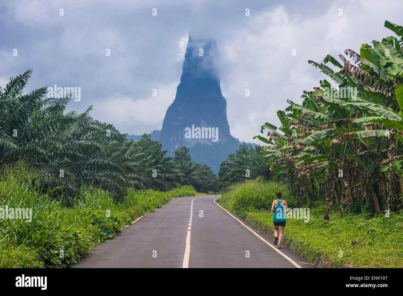 Runner on a road leading to the unusal monolith, Pico Cao Grande, east ...