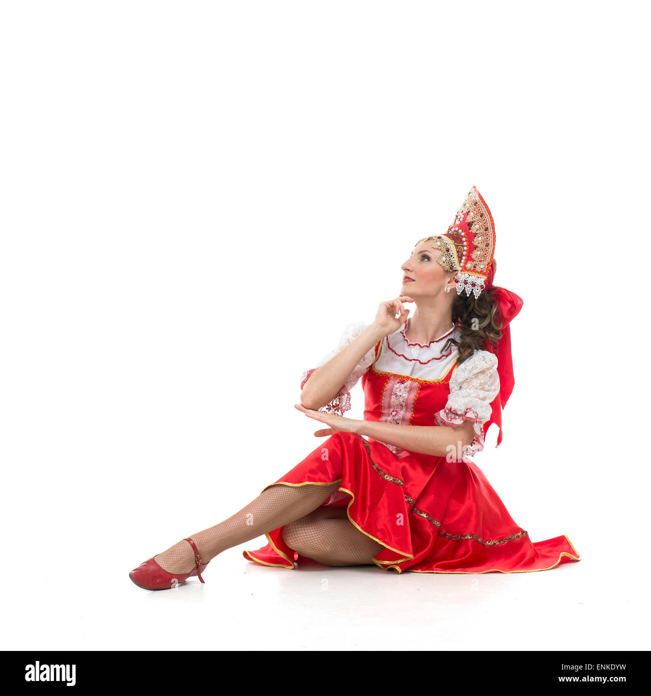 woman in national russian dress sitting on the floor and looking left ...