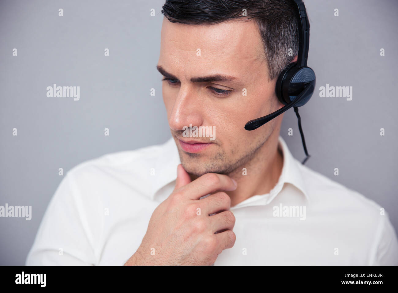 Portrait of a pensive male operator over gray background Stock Photo ...