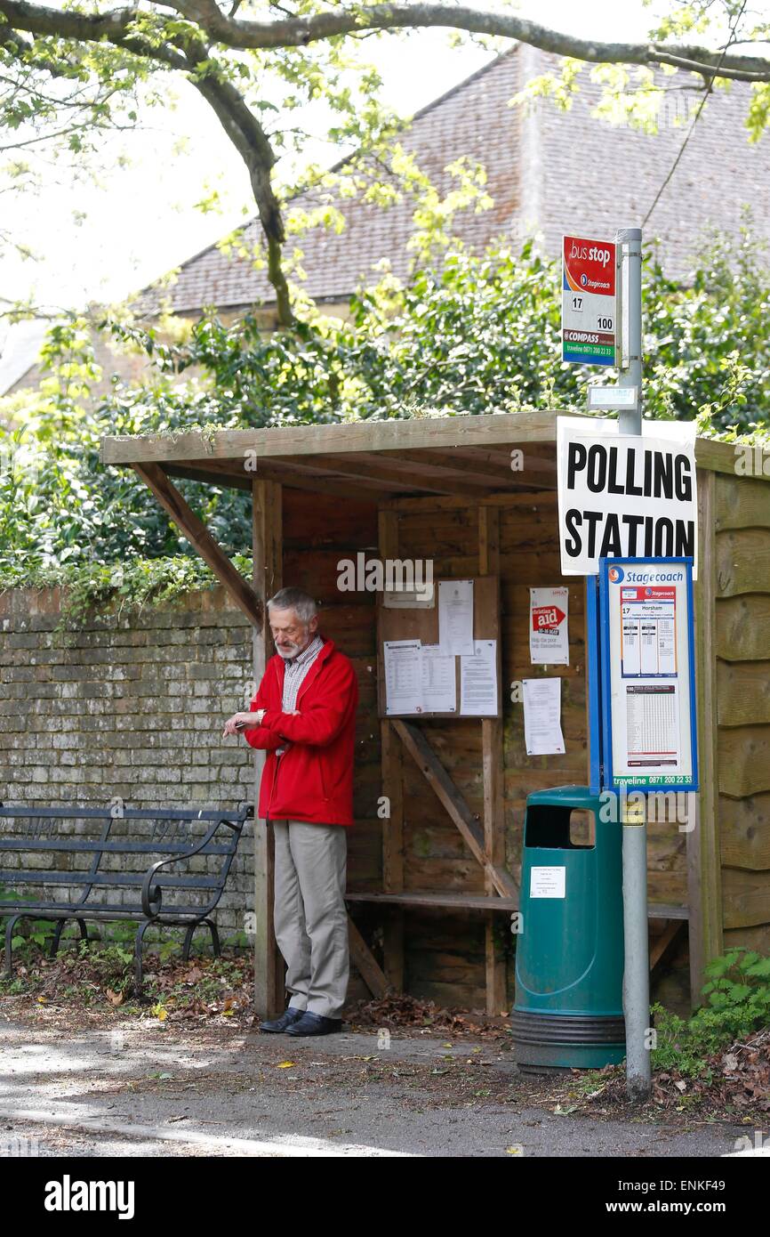 A man waits for a bus in a bus shelter opposite the Polling Station at ...