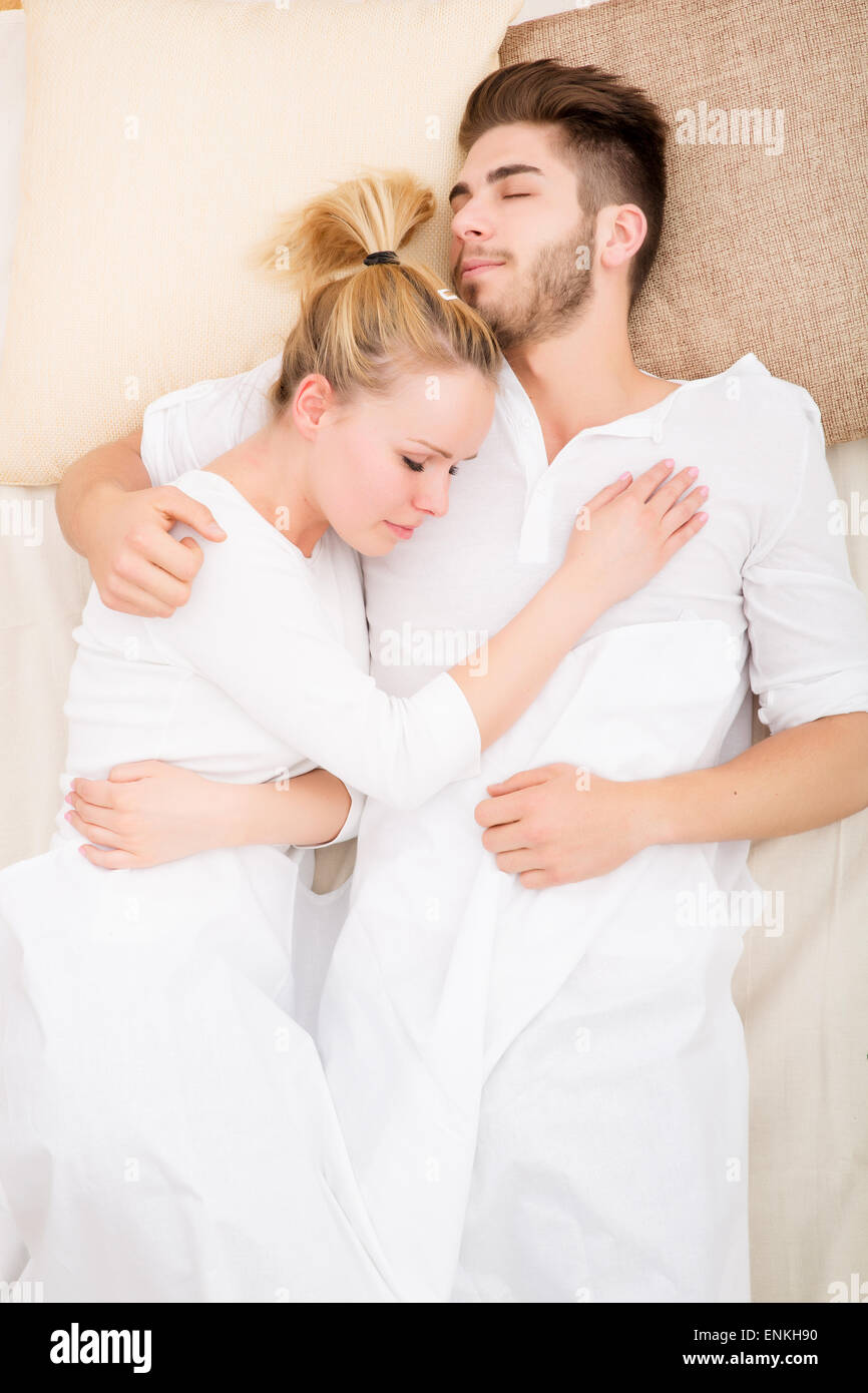 A happy young couple hugging in bed Stock Photo - Alamy