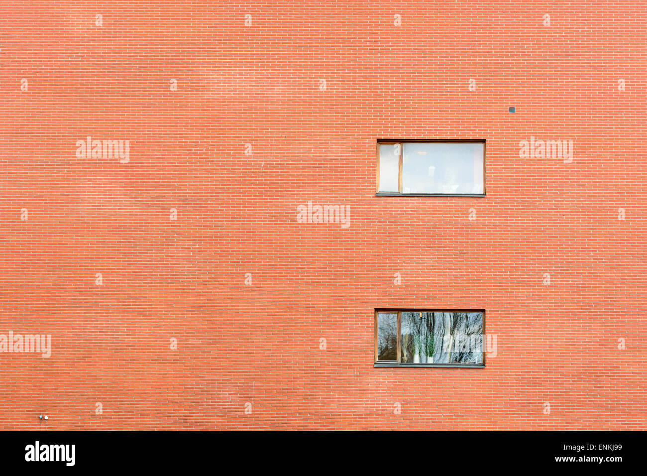 Huge brick wall on modern building with two windows. Reflections in ...