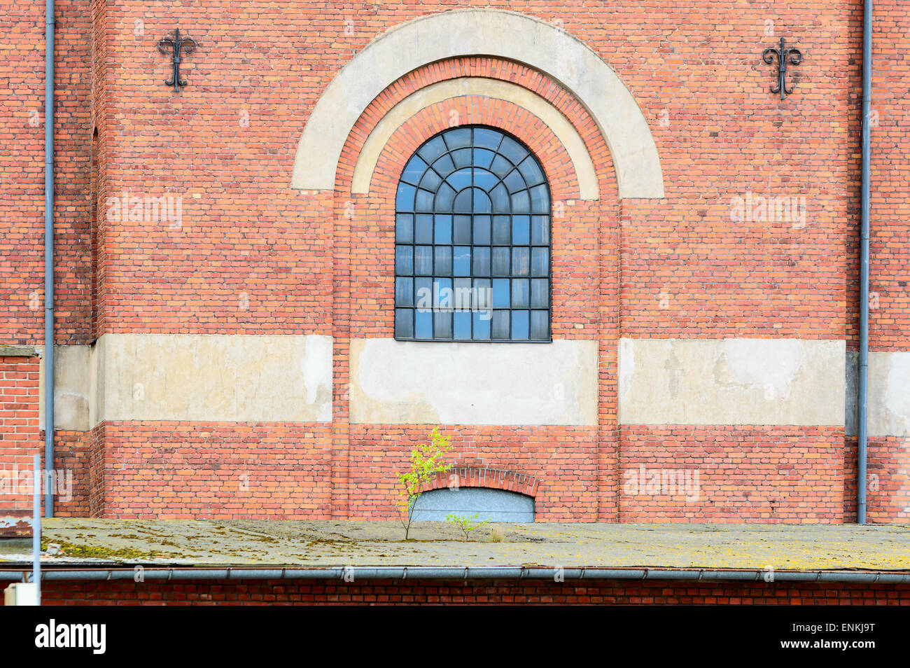 Old brick building in an industrial area. One fine glass window with ...